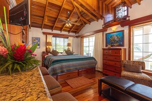 Um quarto amplo com uma cama grande, teto de madeira e vista para o exterior.
