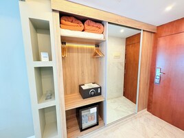 Um closet espaçoso com prateleiras, cabideiro e uma pequena geladeira.
