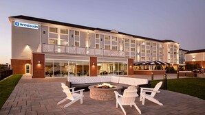 Um hotel Wyndham com área de varanda, lareira e mobiliário para áreas externas.