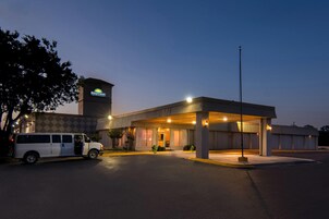 Hotel Days Inn by Wyndham com estacionamento, uma van e um edifício com torre.