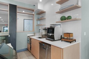 Uma cozinha moderna com uma máquina de café, um mapa na parede e prateleiras de madeira.
