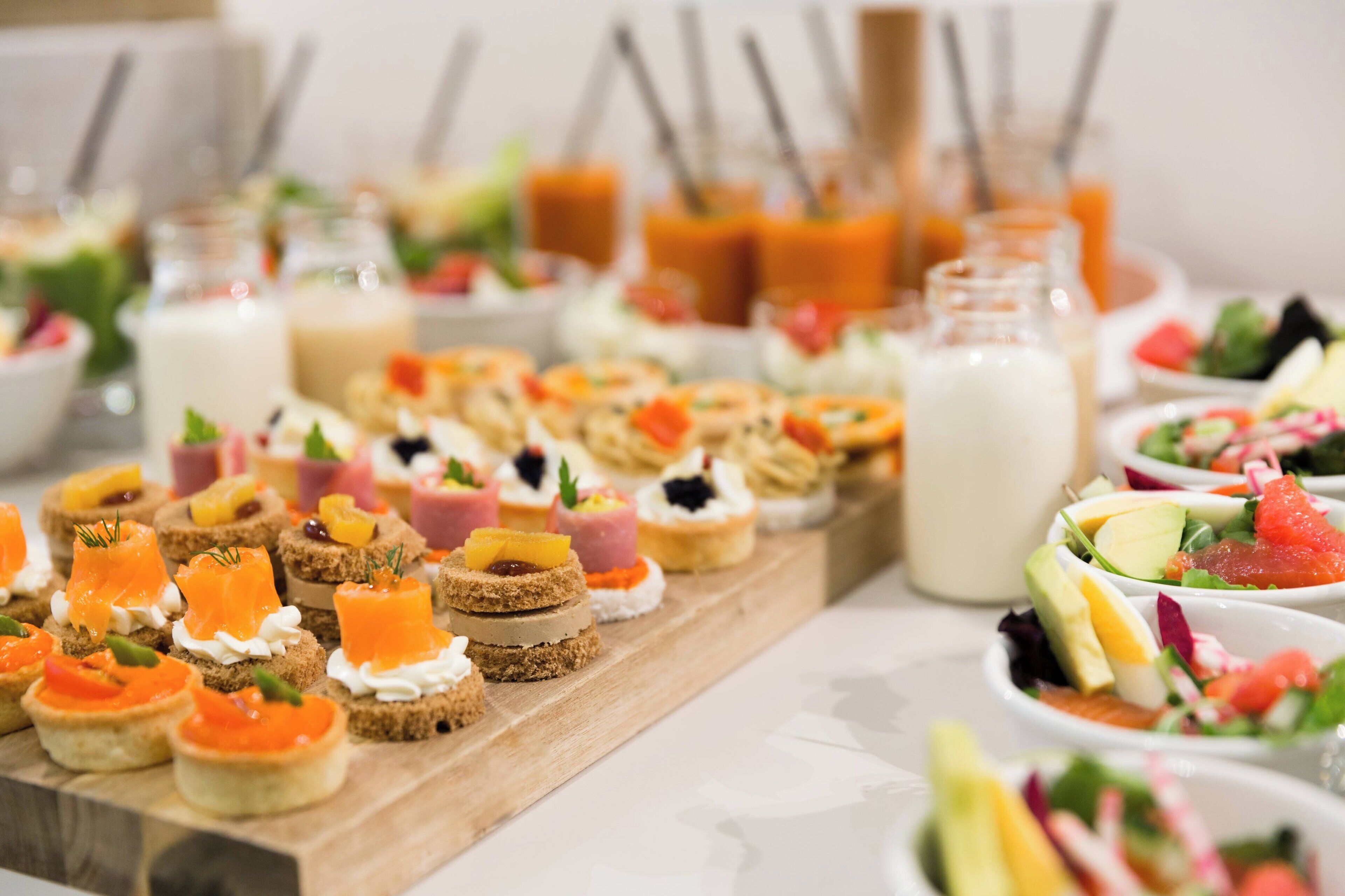 Diversos petiscos e bebidas dispostos numa mesa de buffet.