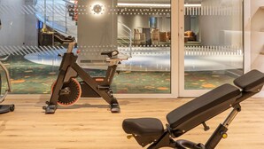 Uma academia com equipamentos de exercícios, escadas e uma área de estar.