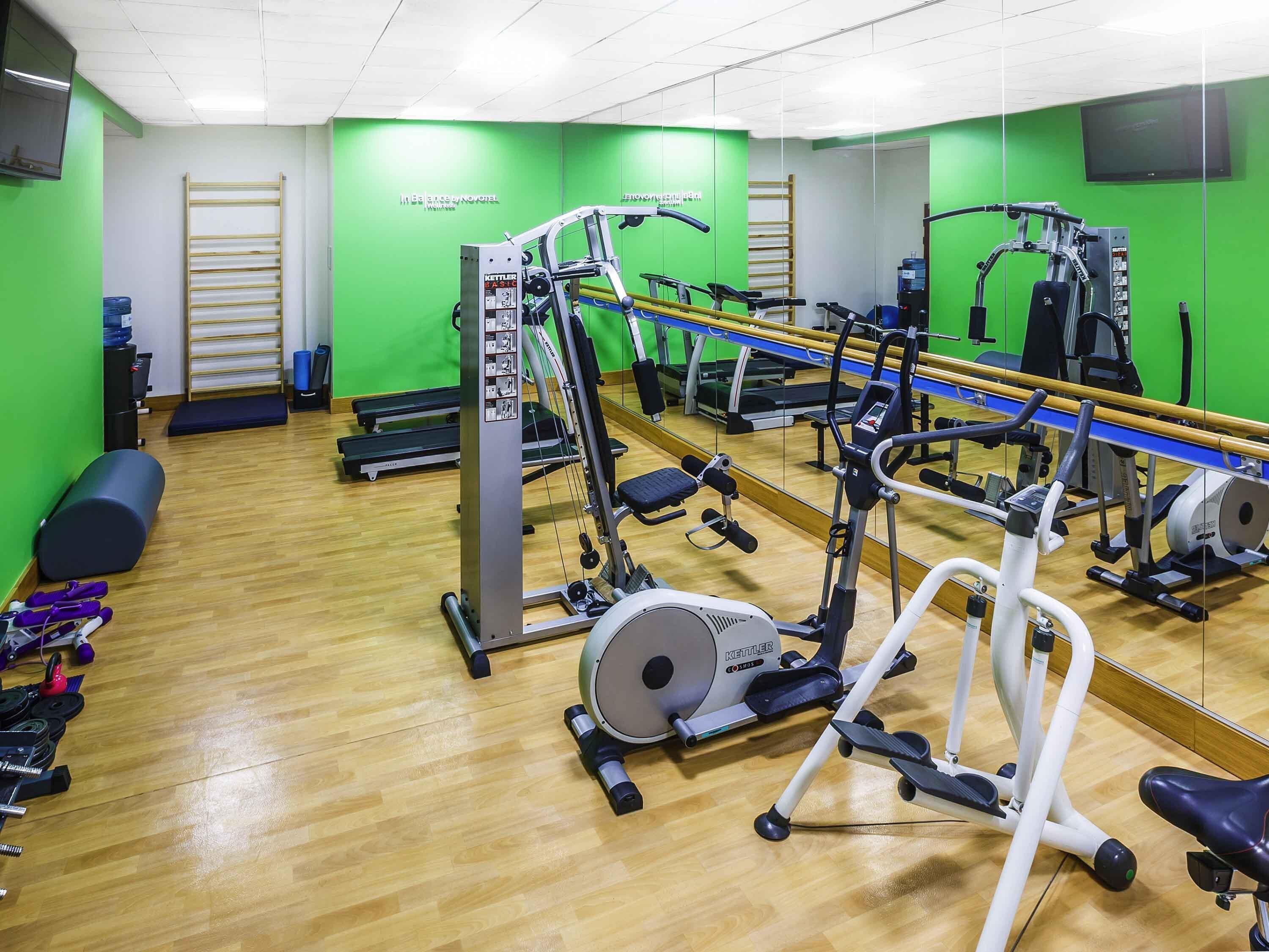 Uma academia com diversos equipamentos de exercício, incluindo esteiras, elípticos e aparelhos de musculação.