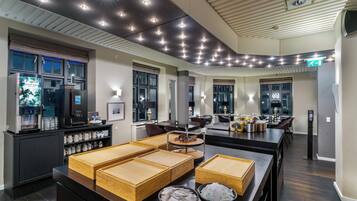 Um lobby moderno de hotel com um balcão de café, área de estar e uma receção.