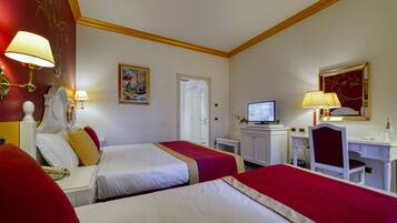 Quarto de hotel com duas camas, uma escrivaninha, uma televisão e um espelho.