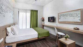 Quarto de hotel moderno com cama, escrivaninha, cadeira e obra de arte na parede.