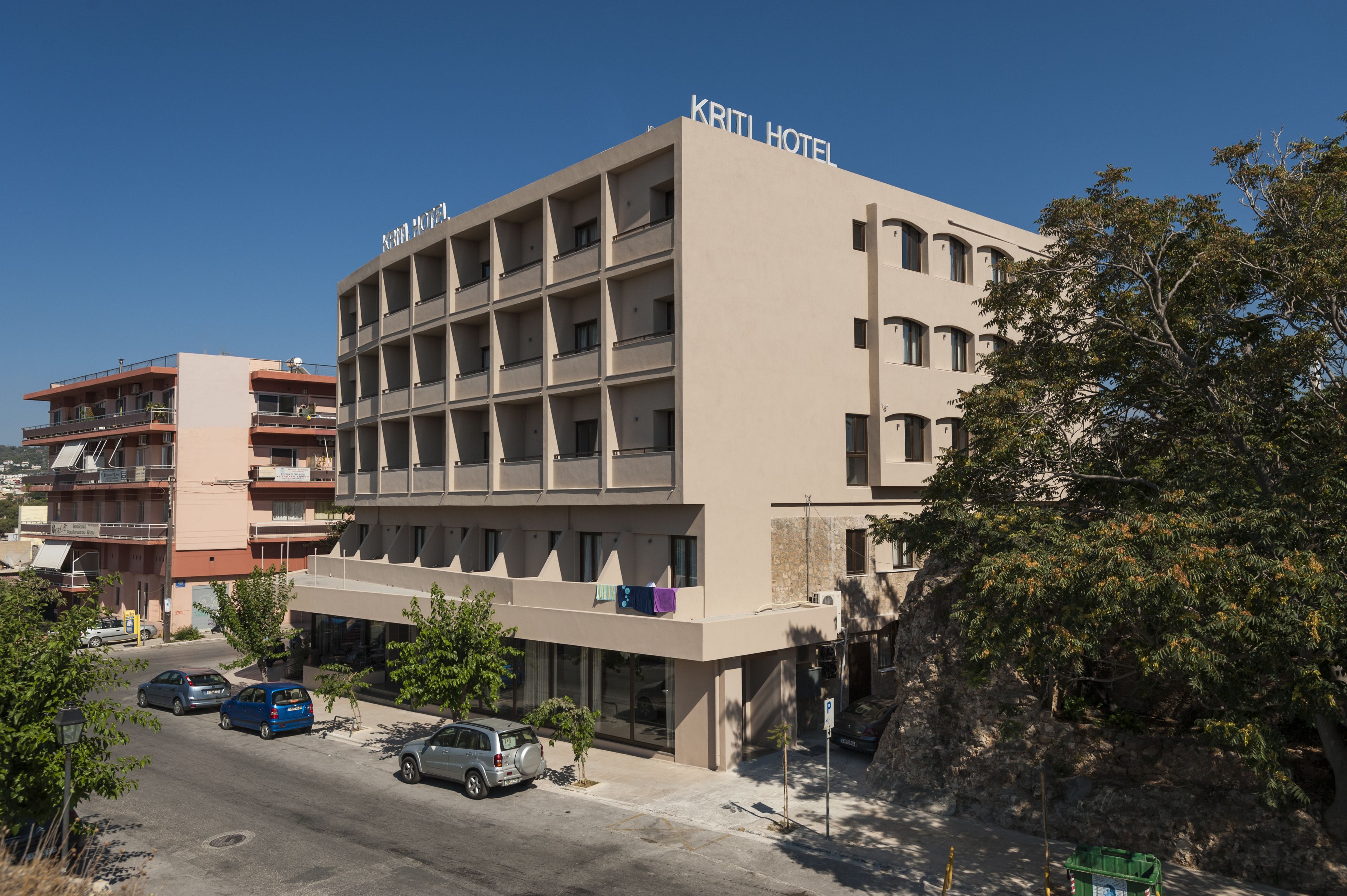 Um hotel moderno com vários andares, varandas e vista desobstruída da área urbana ao redor.