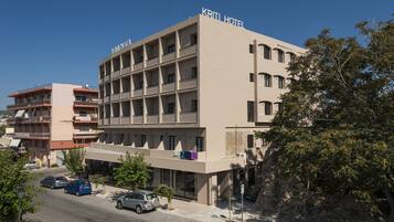 Um hotel moderno com vários andares, varandas e vista desobstruída da área urbana ao redor.