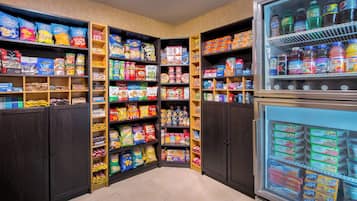 Uma seção bem abastecida com lanches e bebidas em uma loja, com diversas marcas de salgadinhos, cereais e refrigerantes.