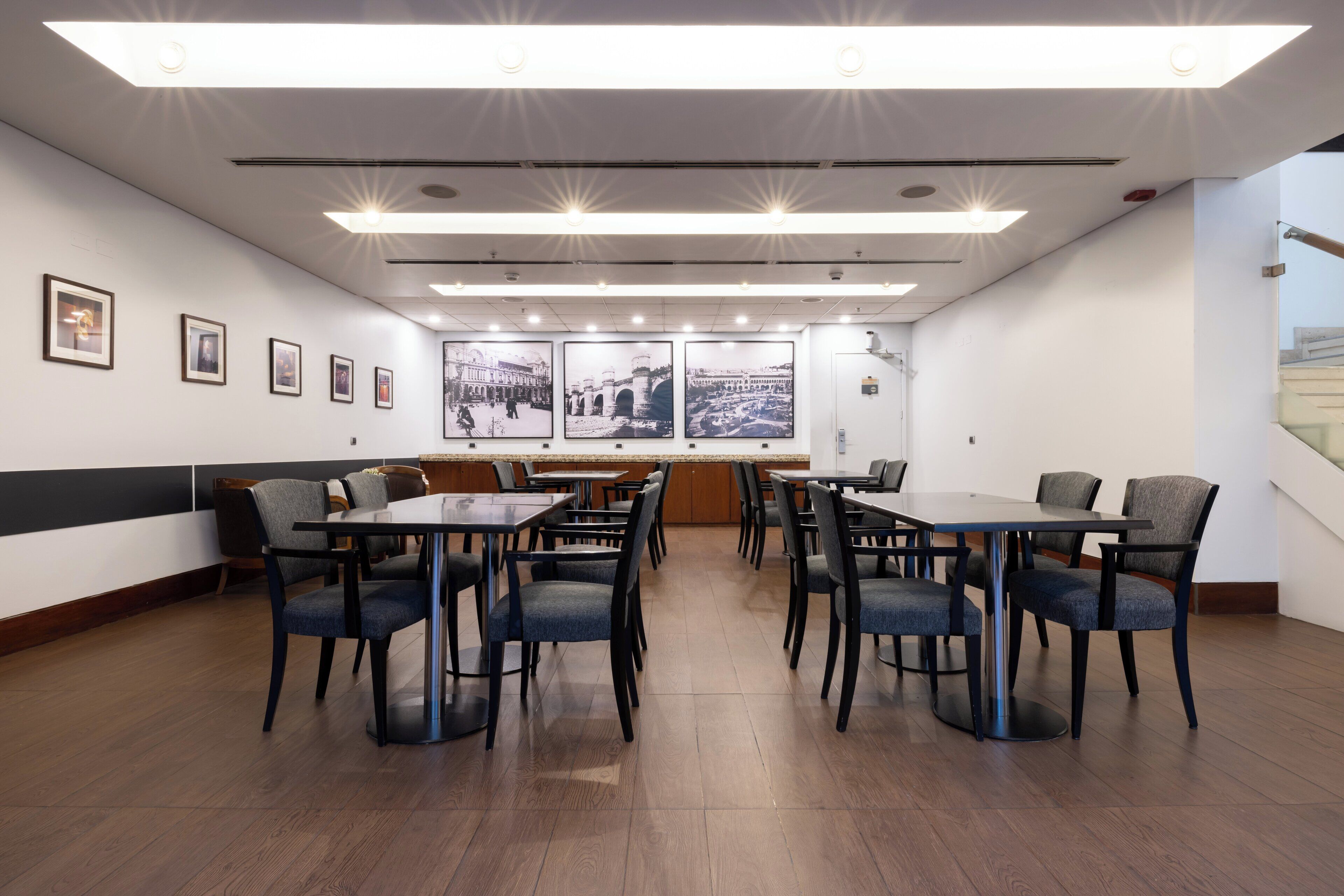 Uma sala de conferência com uma mesa comprida, cadeiras e quadros nas paredes.