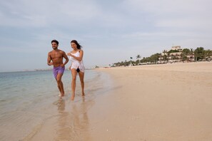 Praia particular, espreguiçadeiras, guarda-sóis, toalhas de praia 