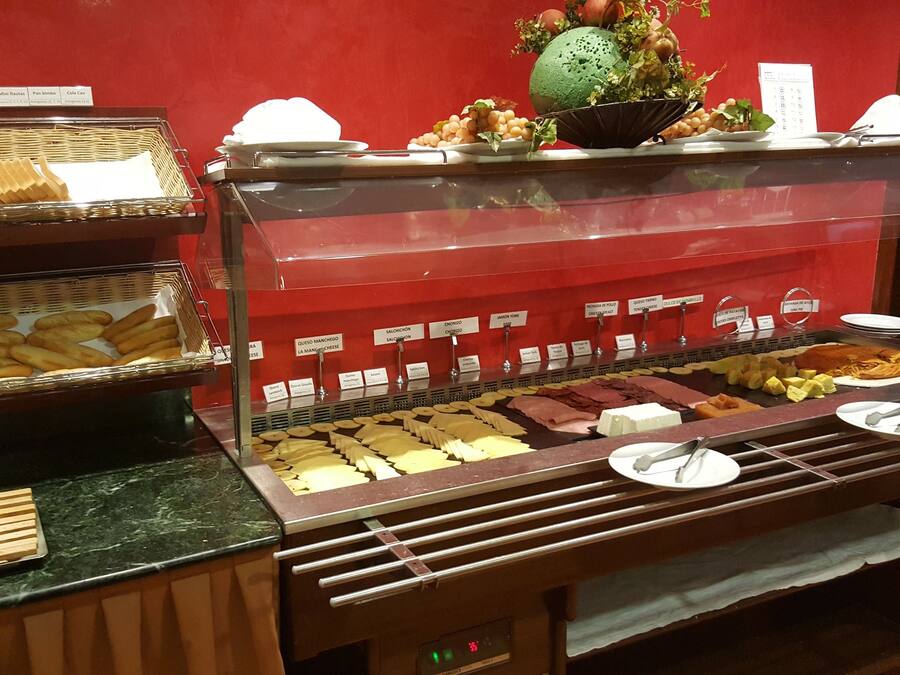 Buffet com diversos alimentos e um relógio.