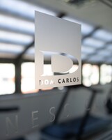 Um letreiro com o nome 'DOM CARLOS' numa fonte moderna e minimalista.
