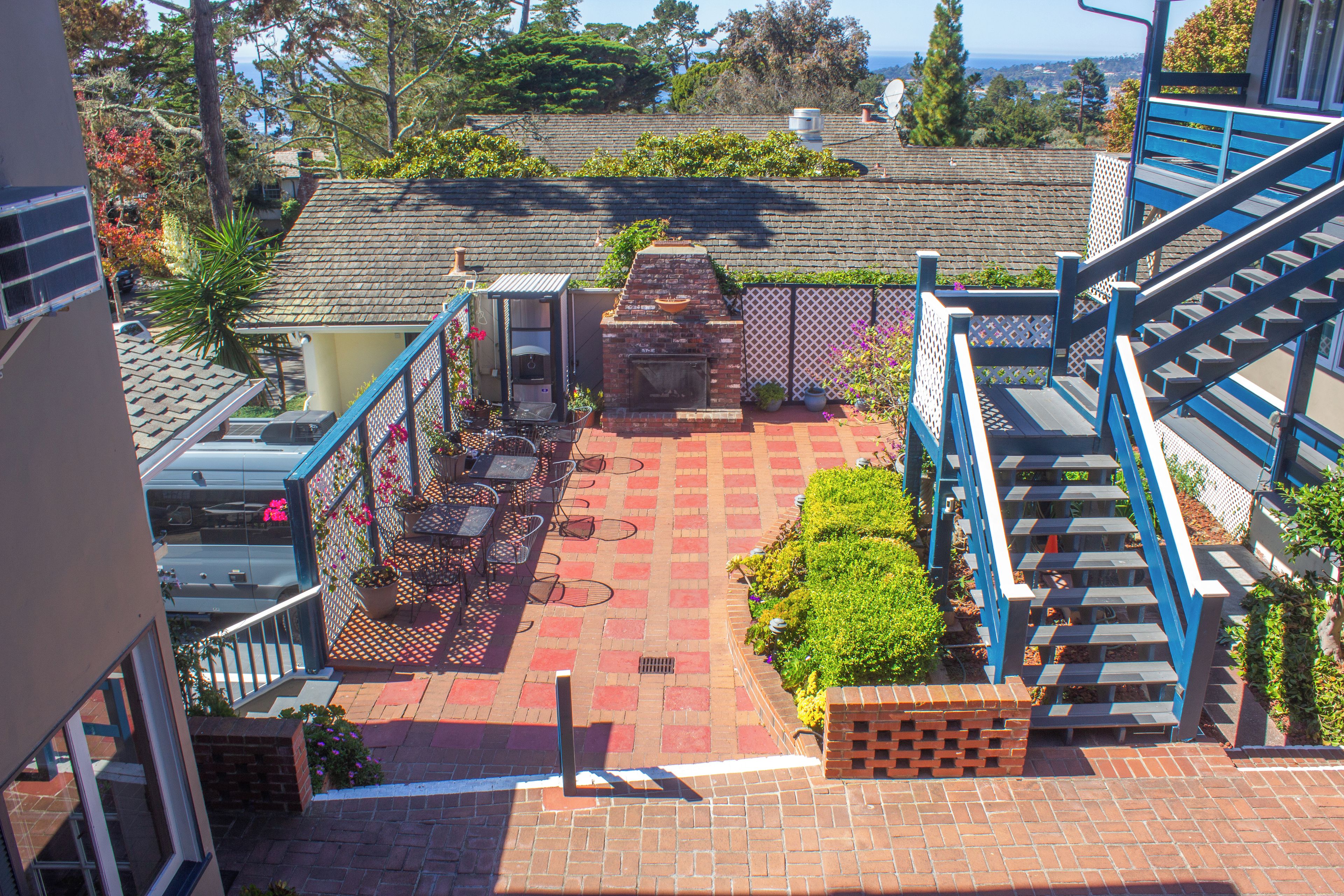 Um terraço no telhado com área de estar ao ar livre, churrasqueira e vista do bairro.