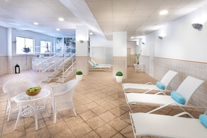 Amplo espaço interno com várias poltronas e uma pequena mesa com uma tigela de frutas.