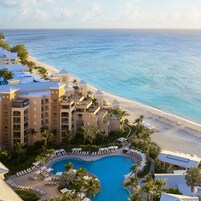 Um resort com piscina, praia e vista para o oceano.