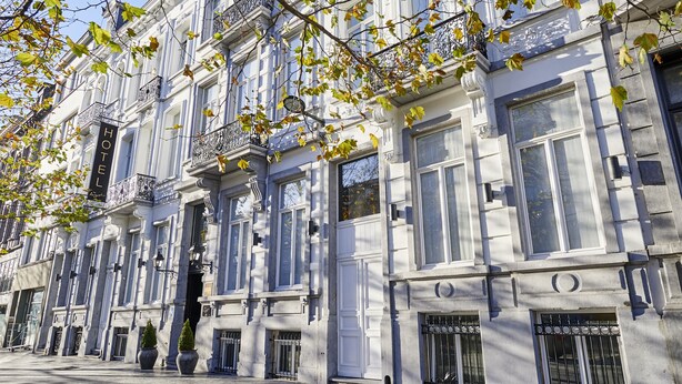 Um edifício histórico com estilo arquitetônico clássico, apresentando varandas ornamentadas e janelas amplas.
