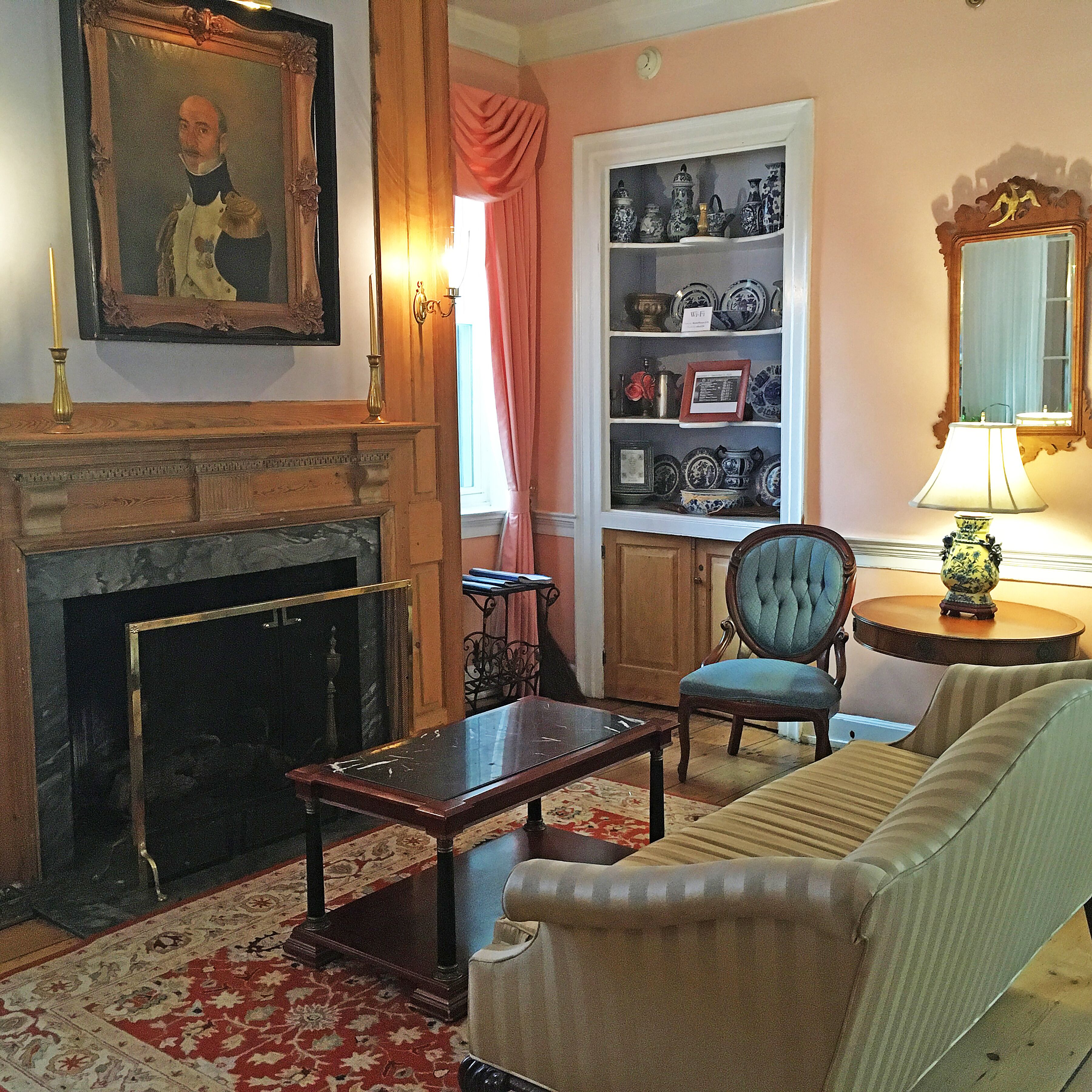 Uma sala de estar tradicional com lareira, estante de livros, sofá confortável e espelho decorativo.