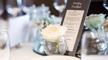 Menu de café da manhã de casamento com uma rosa branca em um vaso de vidro.