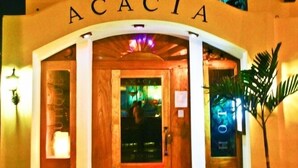 A entrada de um edifício com o nome 'ACACIA' sobre a porta.