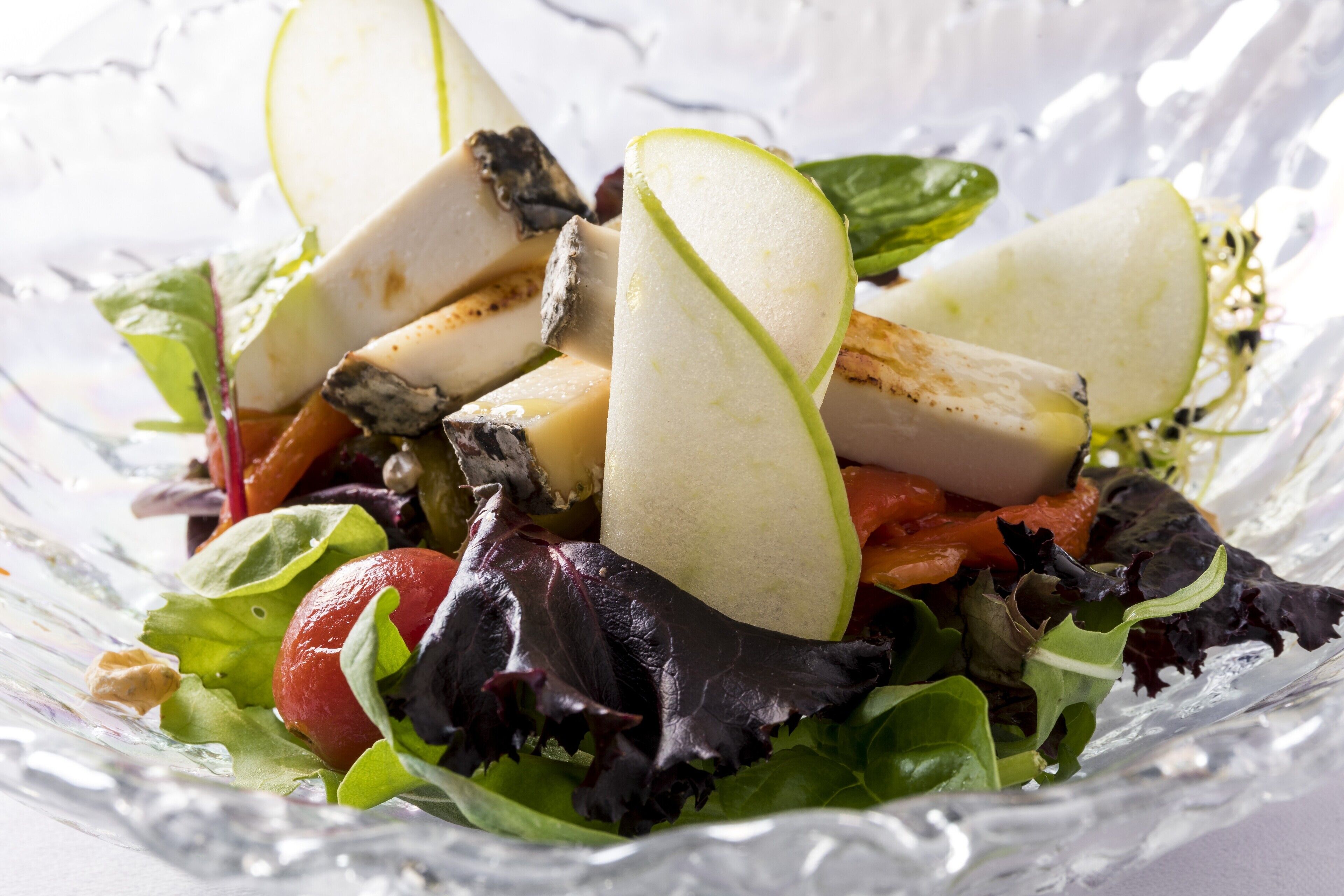 Salada com diversos vegetais e fatias de maçã.