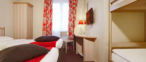 Quarto de hotel com duas camas, uma escrivaninha, uma cadeira, uma televisão e um guarda-roupa.