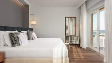 Quarto de hotel com uma cama grande, uma cadeira, um espelho e vista da cidade.