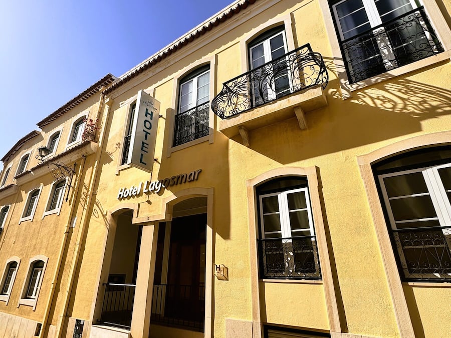 Um edifício amarelo com uma placa indicando
