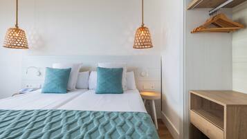 Quarto bem arrumado com uma cama, duas mesas de cabeceira, um lustre e uma estante de madeira.