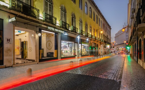 Um hotel com fachada clássica, janelas amplas e entrada visível.
