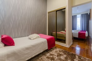 Quarto de hotel com cama, espelho e porta de correr.