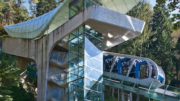 Uma estrutura arquitetônica moderna com um elevador em vidro e um design de telhado curvo e singular.