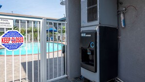 Área da piscina com aviso indicando horário de funcionamento e notificação de 'MANTENHA FECHADO' devido a preocupações com a saúde.
