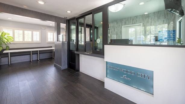 Uma área de recepção com design moderno, incluindo um balcão, um banco e um grande janelão.