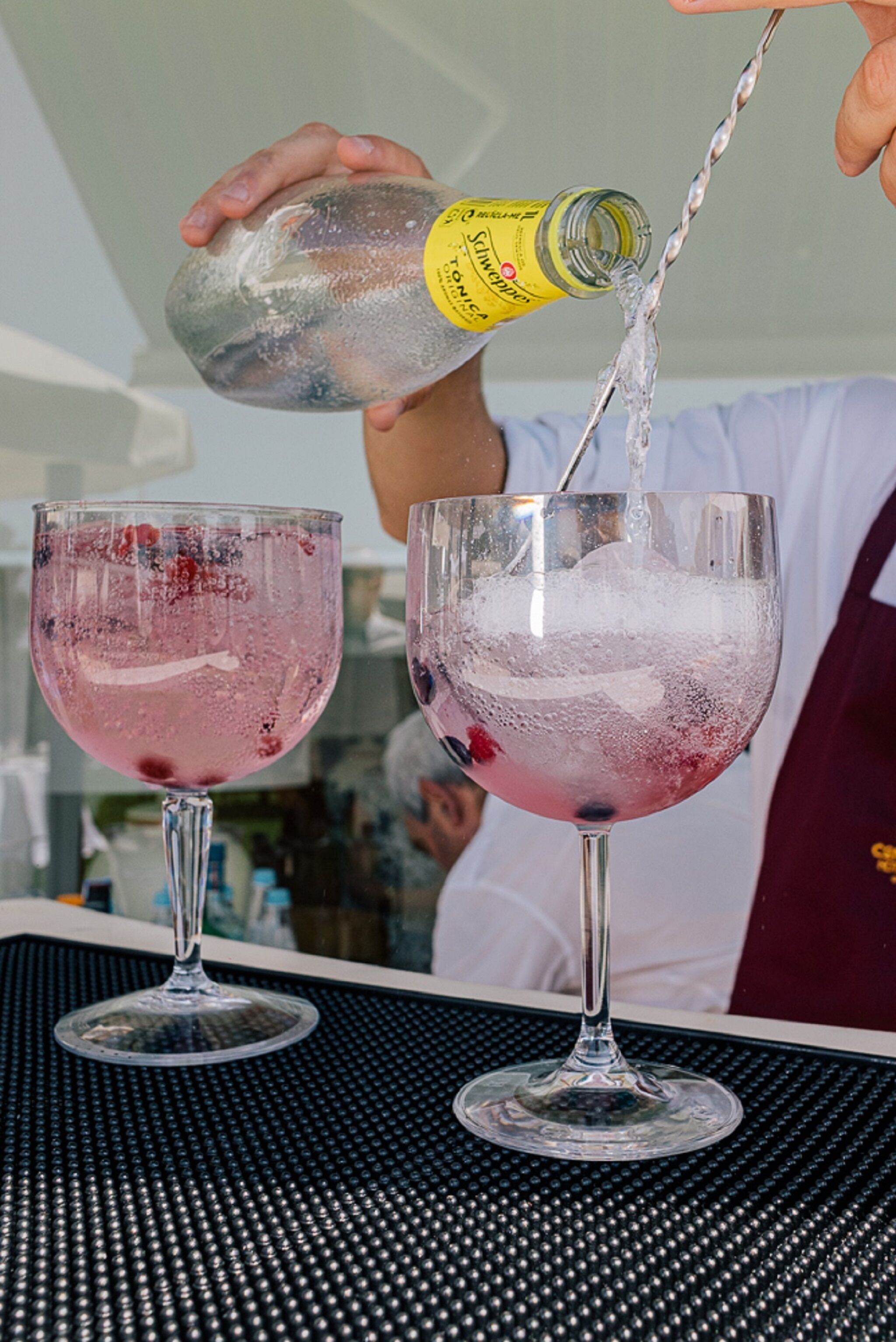Um bartender servindo uma bebida em um copo.