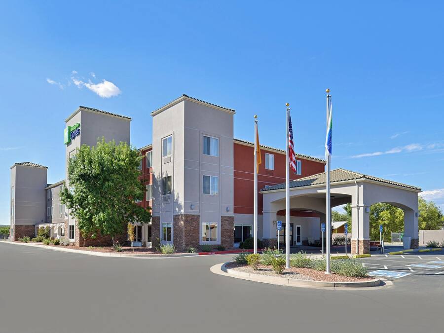 Hotel com um pátio central, várias mastros de bandeira e um céu azul límpido.
