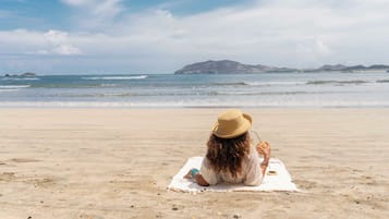 Na praia, guarda-sóis, toalhas de praia, massagens na praia