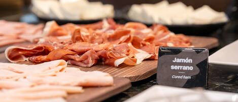 Uma seleção de presunto curado em uma tábua de madeira com uma etiqueta que diz "Jamón serrano presunto curado".