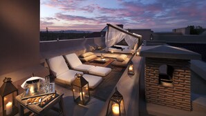 Um terraço no telhado com cama de dossel, cadeiras de descanso e lareira de tijolos.
