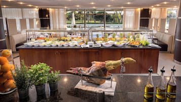 Buffet com diversos alimentos e um leitão assado como peça central.