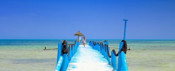 Praia particular, espreguiçadeiras, guarda-sóis, toalhas de praia