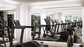Uma academia com várias esteiras e bicicletas de exercício, paredes com espelhos e um design moderno e limpo.