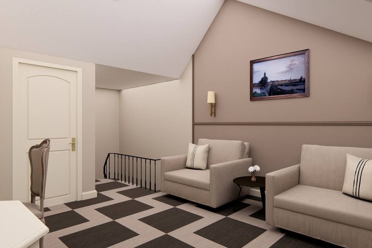 Quarto de hotel com dois sofás, uma mesa pequena, uma cadeira, chão xadrez e um quadro na parede.