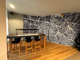 Uma área de refeições com um mural de mapa, uma mesa e quatro cadeiras.