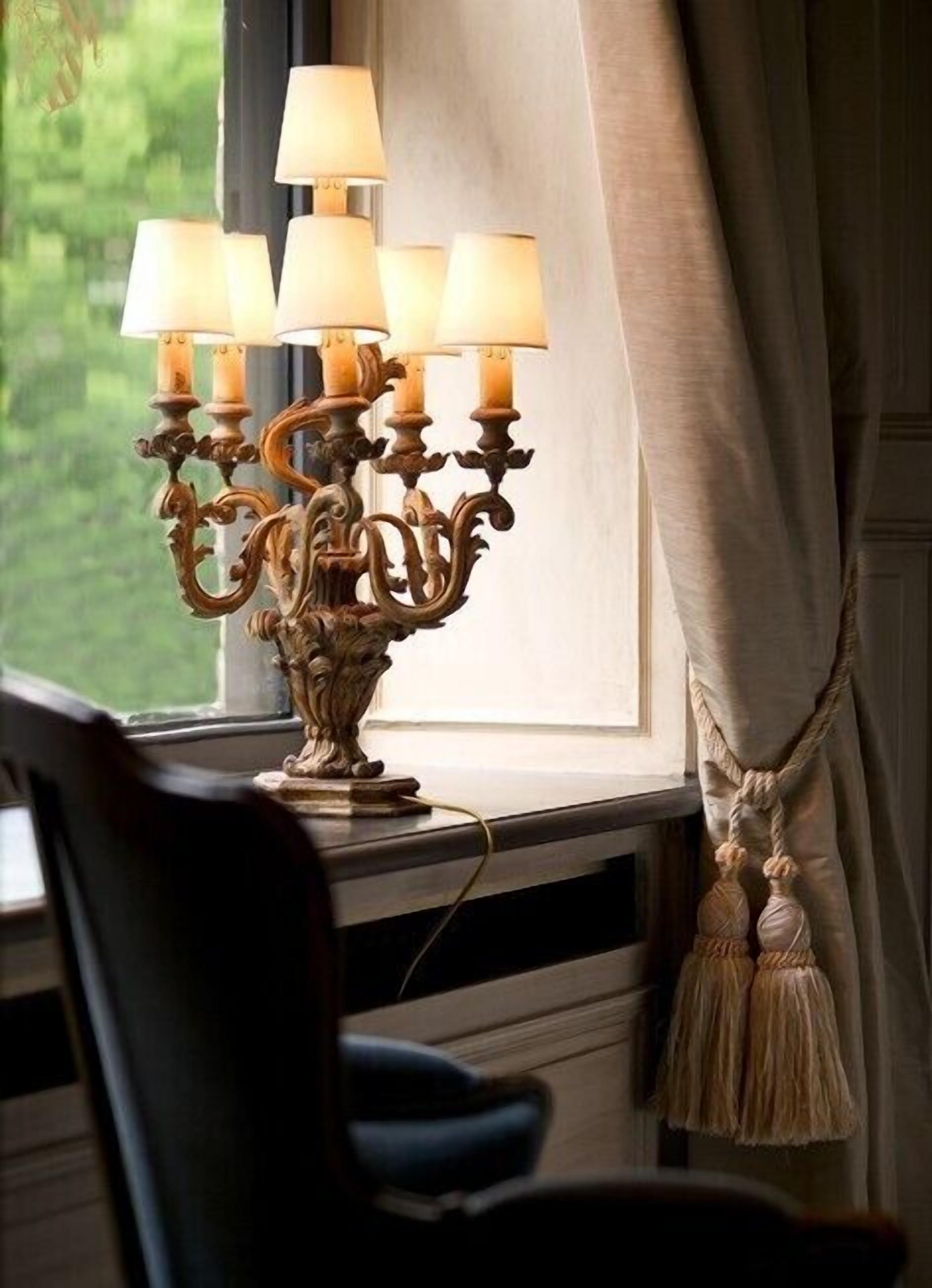 Um candelabro com várias velas numa janela.