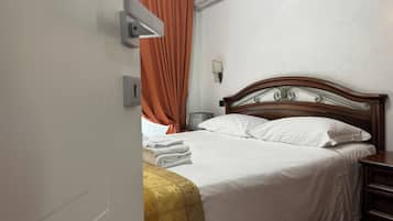 Cama bem arrumada com lençóis brancos, cabeceira de madeira e ar condicionado fixado na parede.