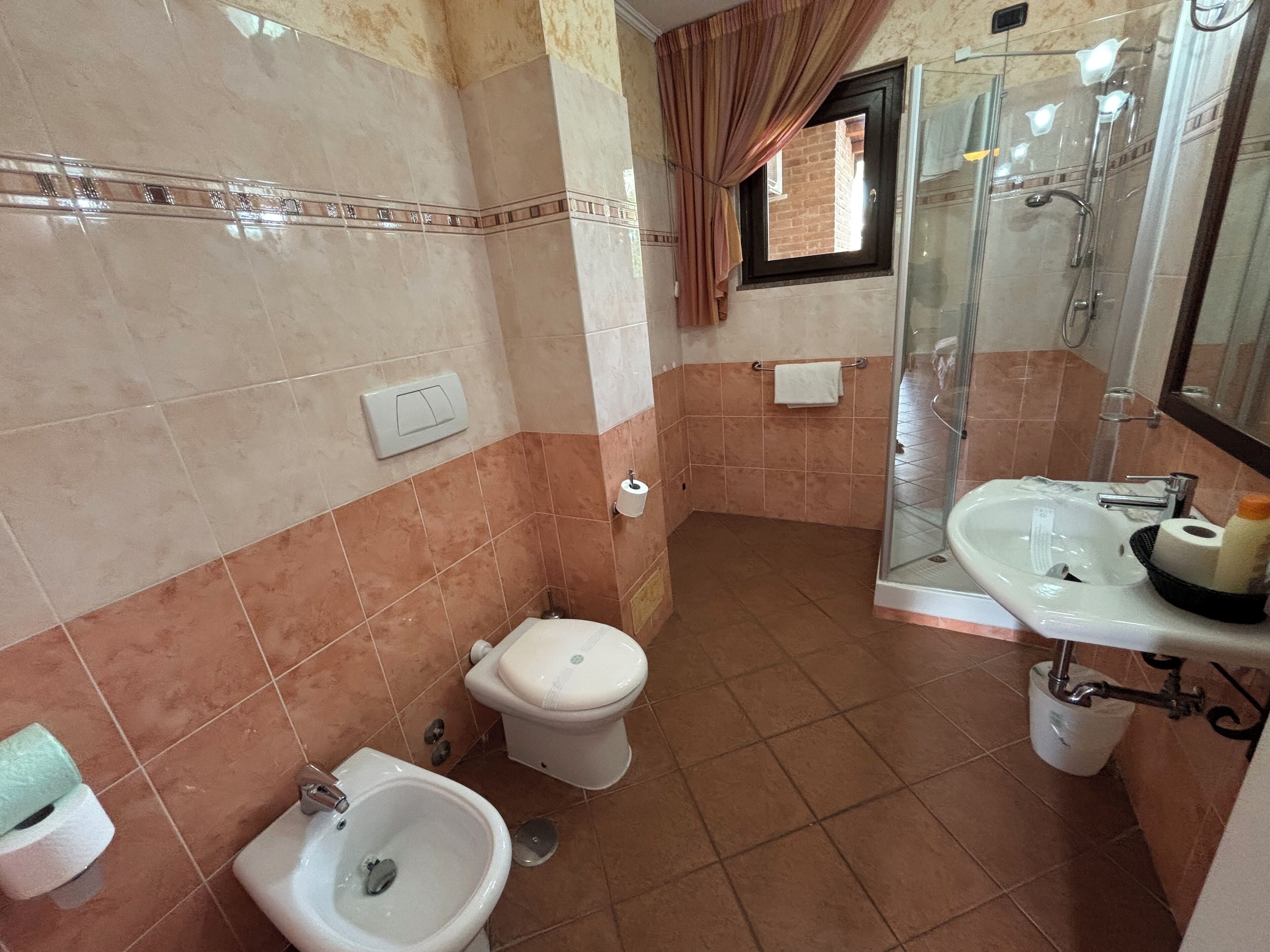 Uma casa de banho com sanita, bidé e lavatório.