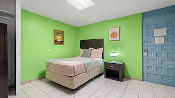 Quarto com cama, mesa de cabeceira e porta azul.