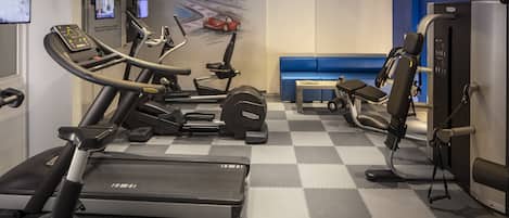 Uma academia com esteiras, bicicletas ergométricas e aparelhos de musculação.